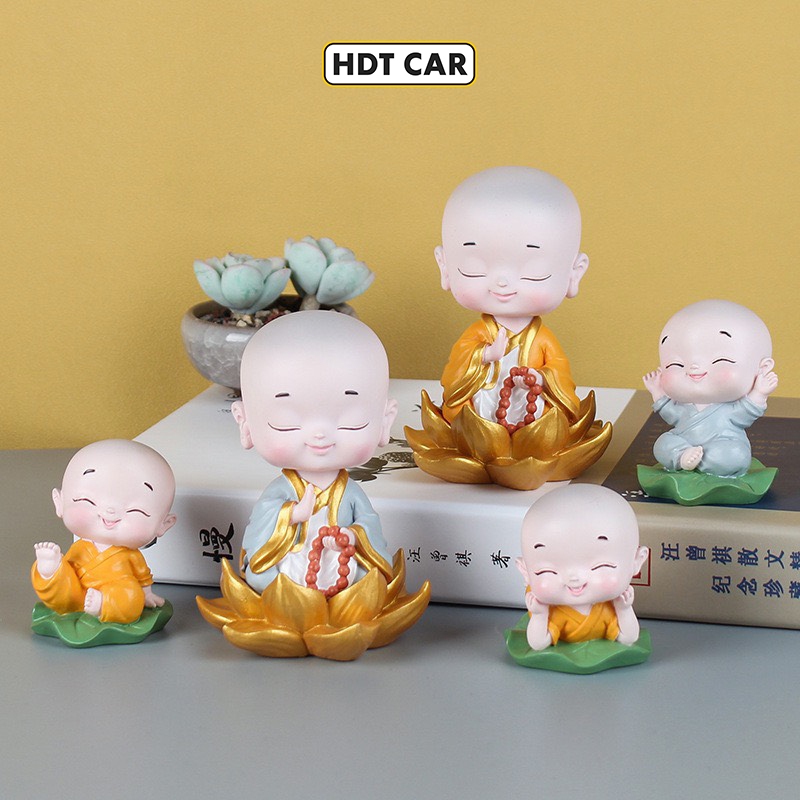 Statue of a monk shaking his head and 4 little monks sitting on a lotus ...