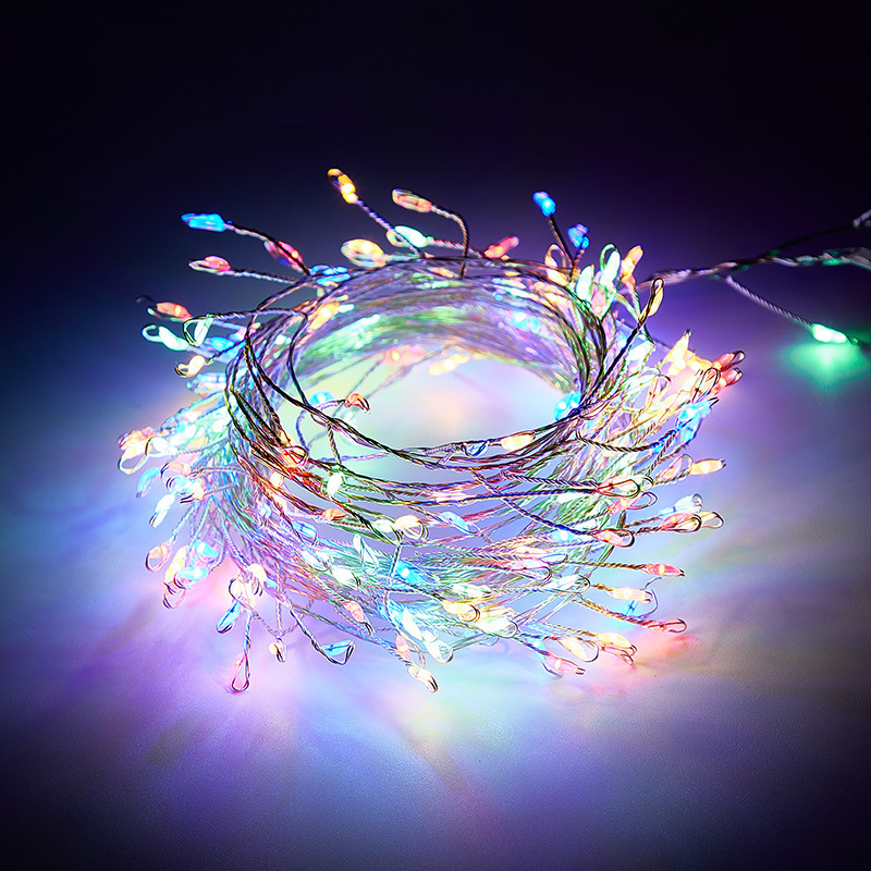 Decorative string lights wrapped around trees with laurel wreaths ...